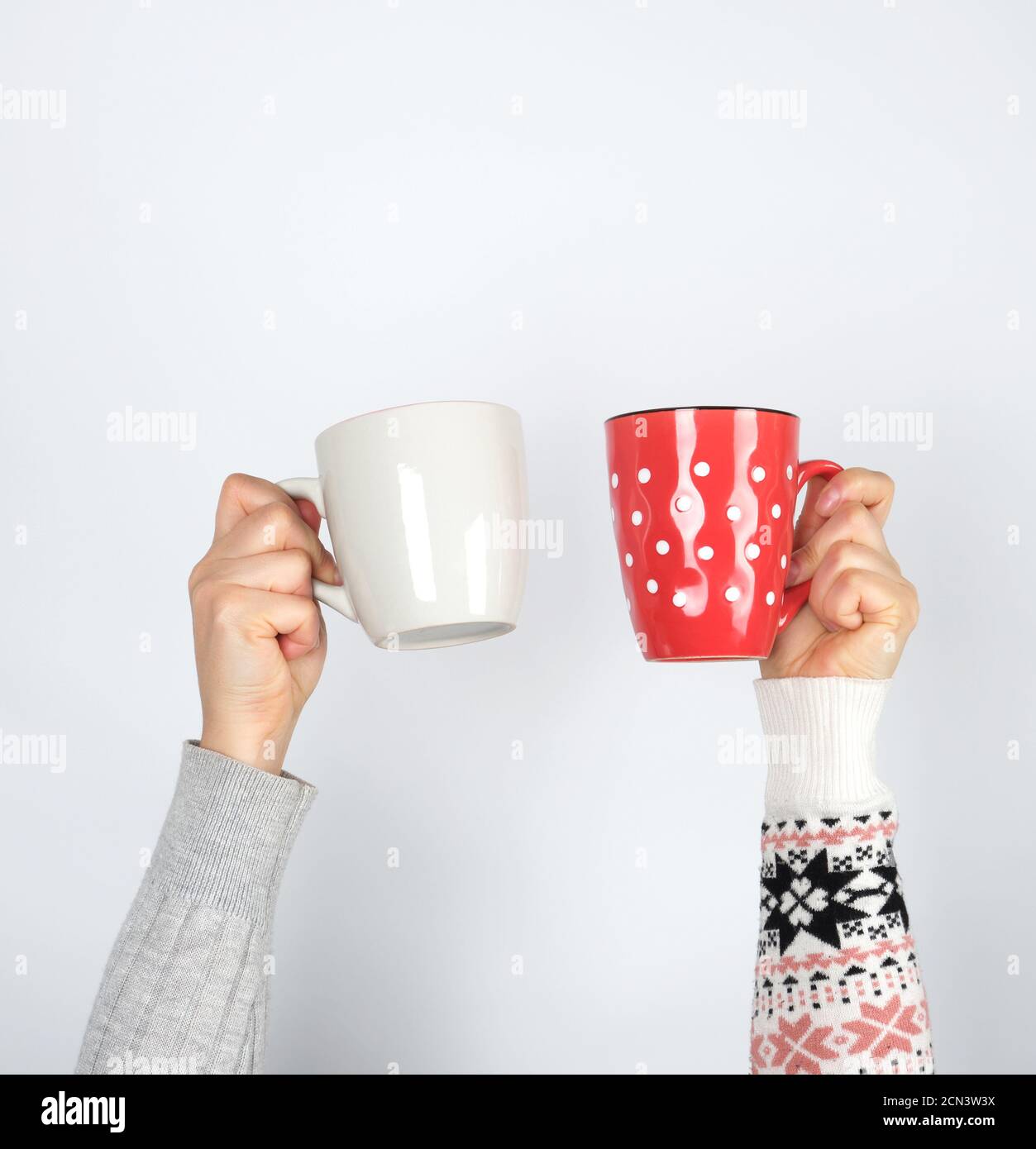two hands holding ceramic mugs on a white background, copy space Stock ...