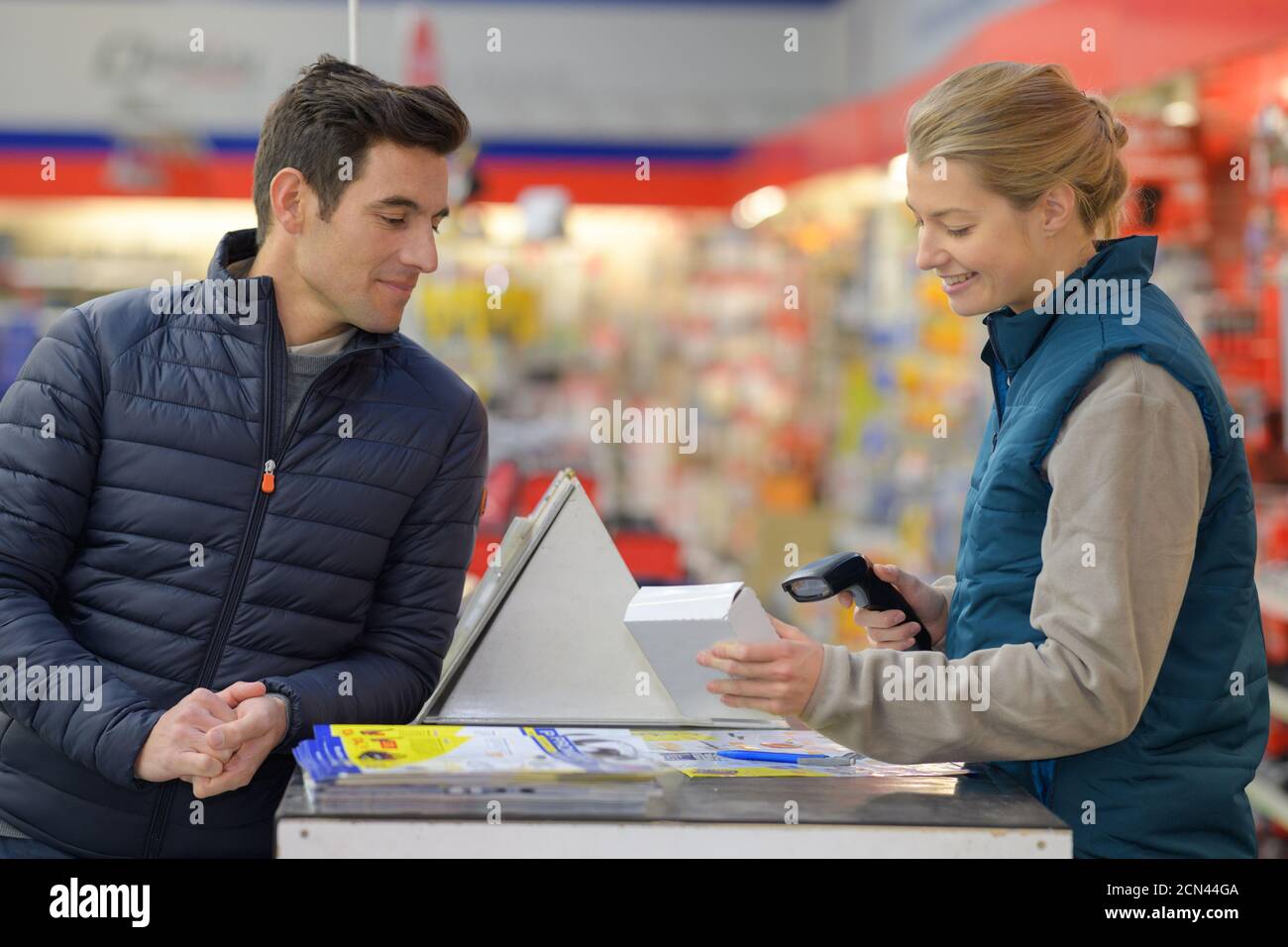 sales assistant scanning product at checkout Stock Photo - Alamy