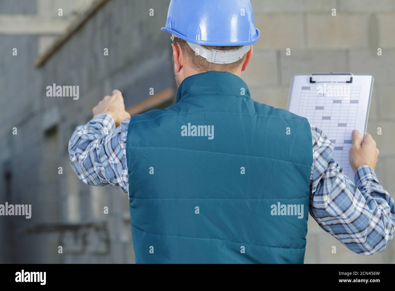 male builder pointing at structure Stock Photo - Alamy