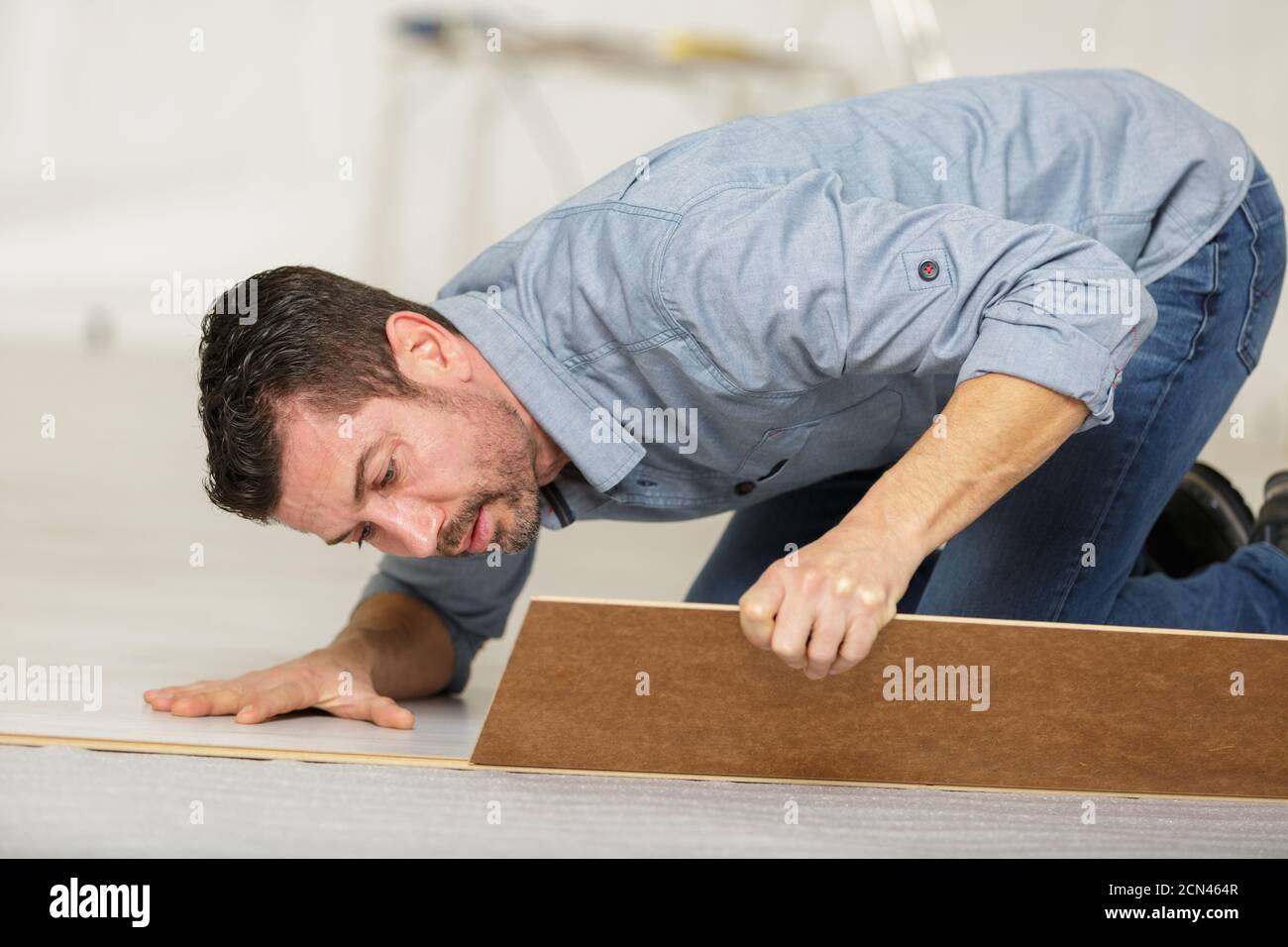 a man during flooring installation Stock Photo - Alamy