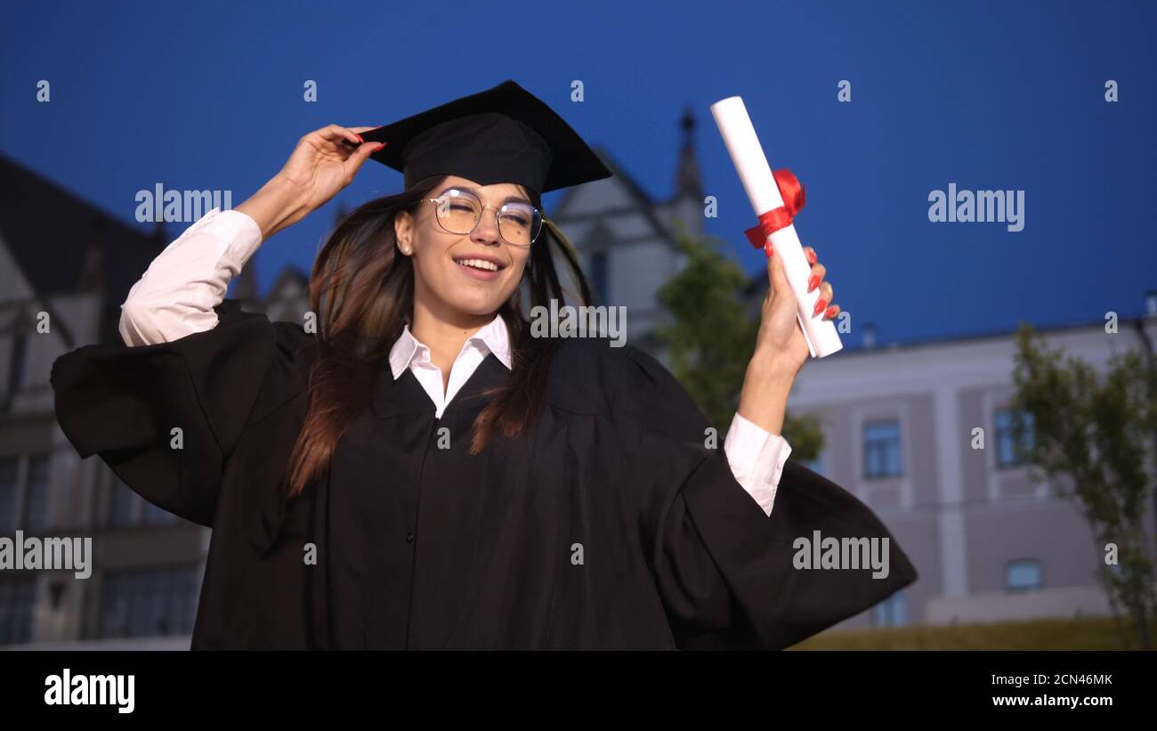 Happy graduating female student dancing Stock Photo - Alamy