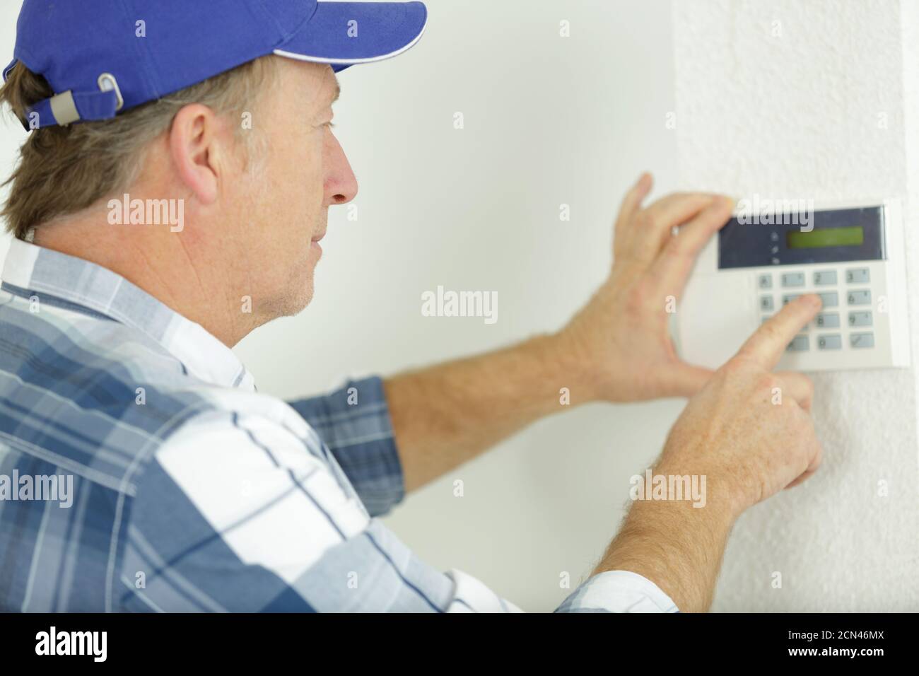 senior workman programming electronic keypad Stock Photo - Alamy