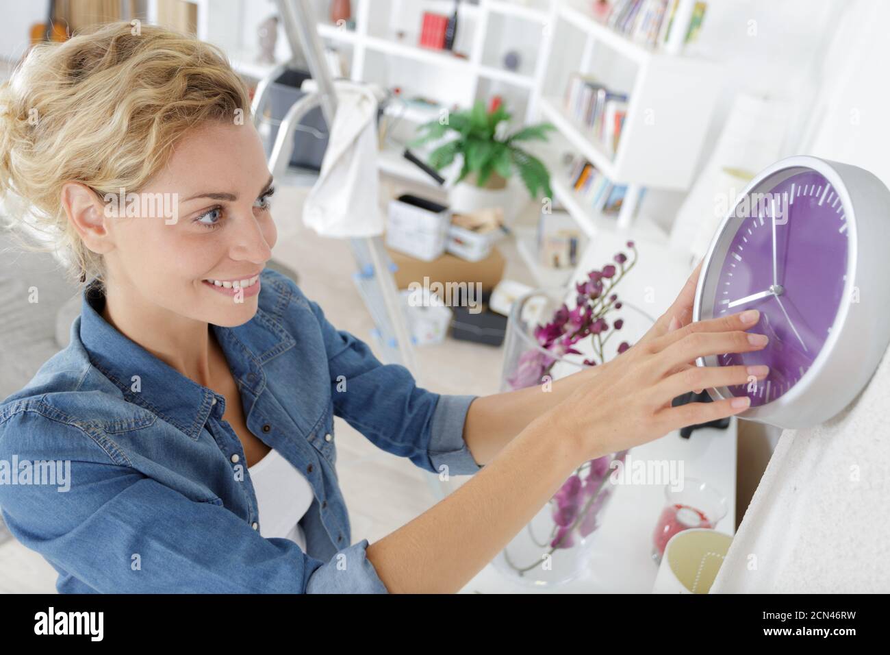 woman changing time on big wall clock Stock Photo - Alamy