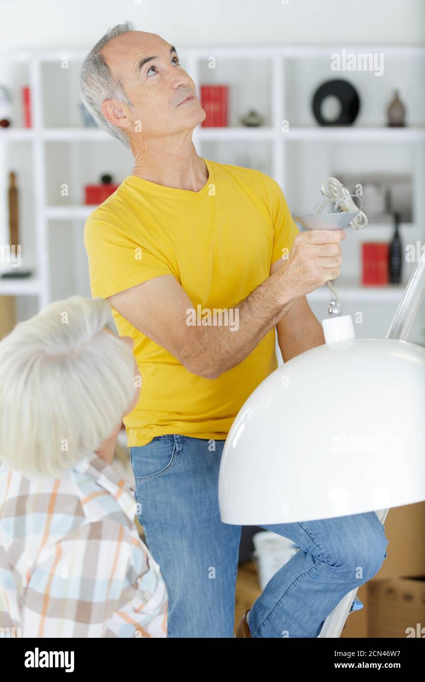 senior man installing light shade home Stock Photo - Alamy