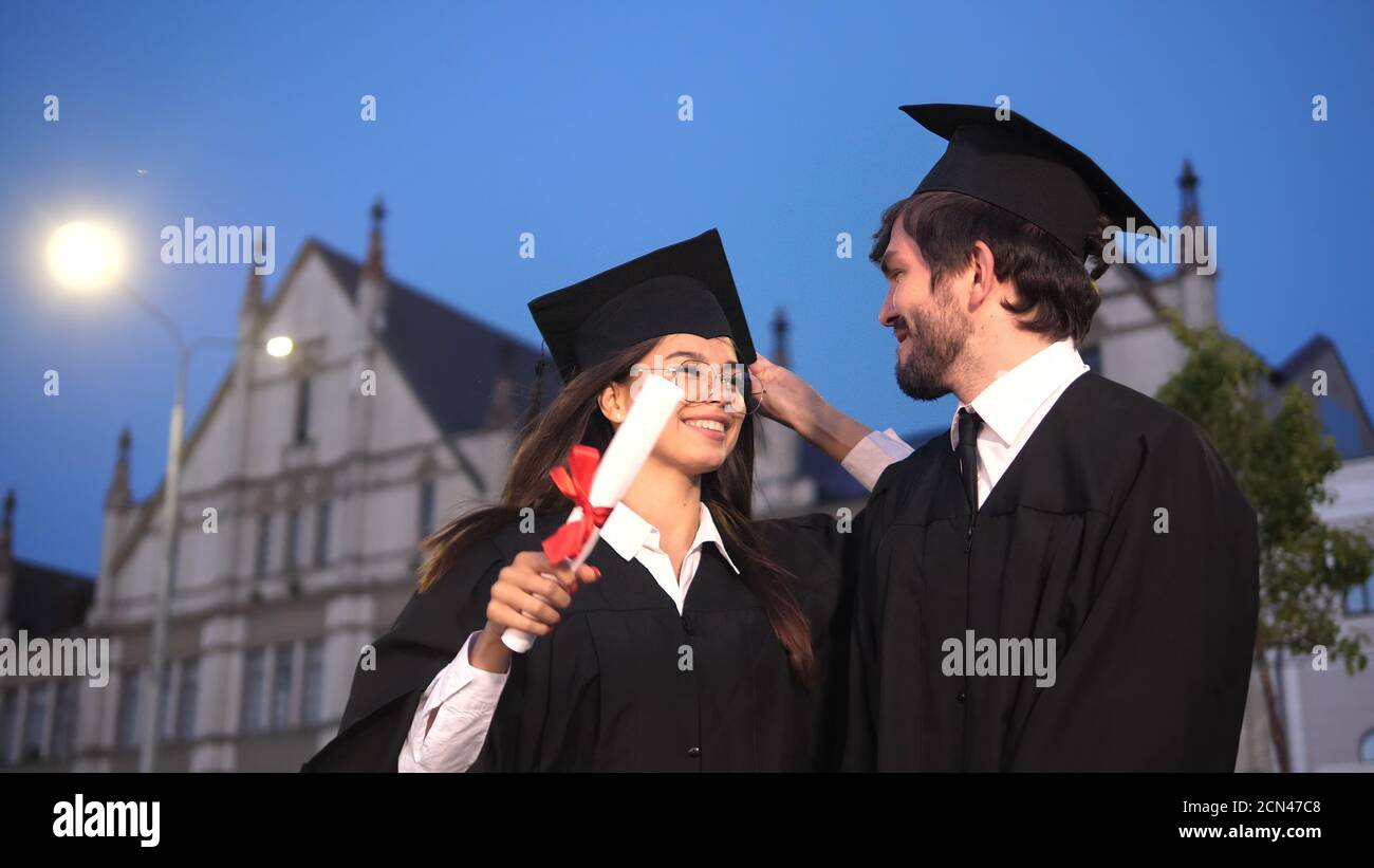 Funny graduates in academic gowns dancing and fooling around after ...