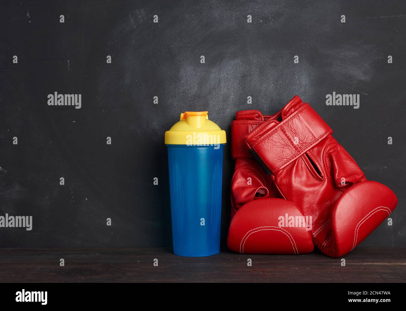 pair of red leather boxing gloves and blue plastic bottle Stock Photo ...