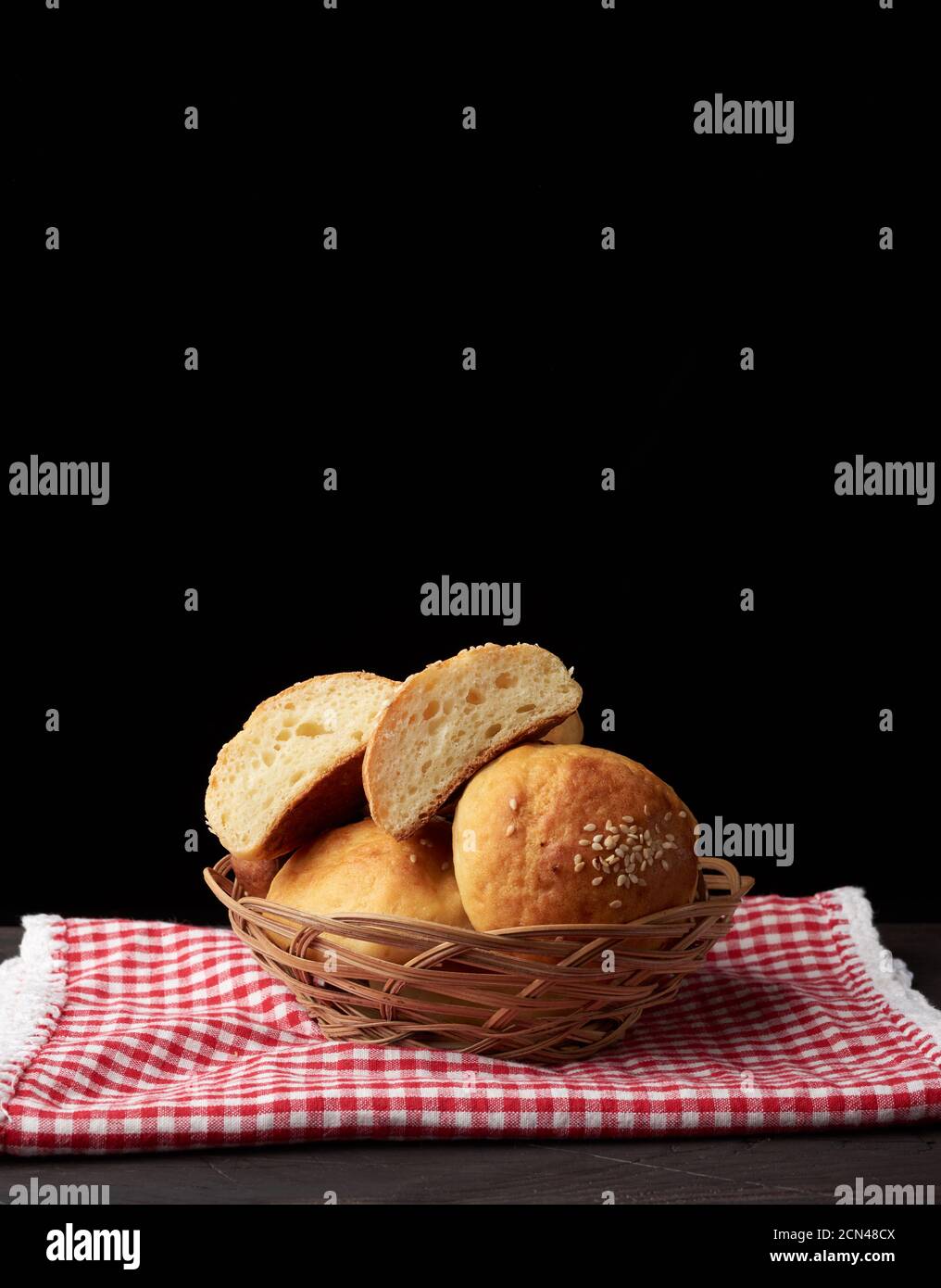 baked round bun with sesame seeds, black background, home baking Stock ...