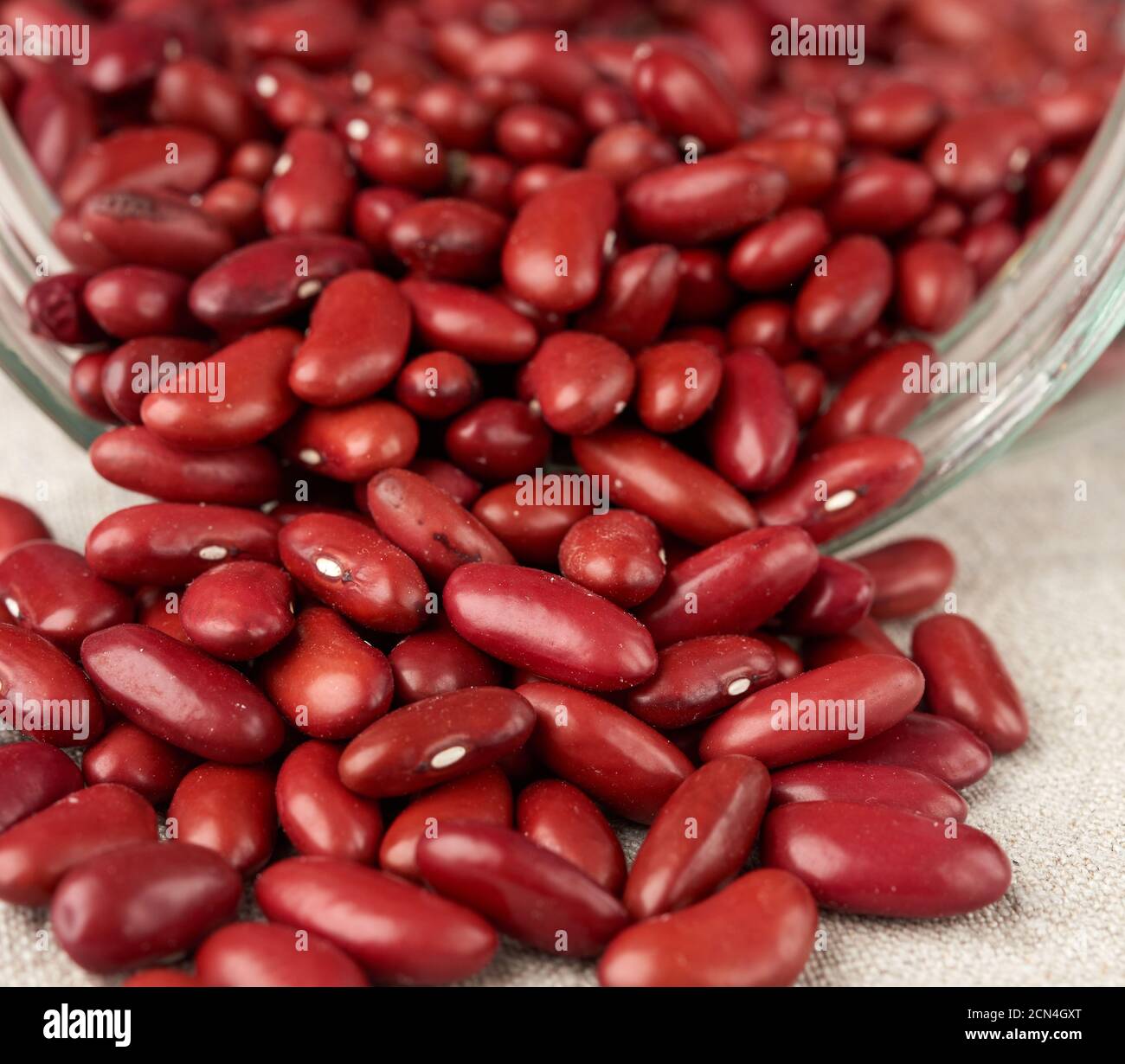scattered red raw beans from a glass jar on a gray linen napkin Stock ...