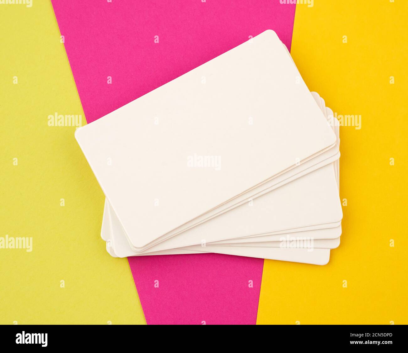 stack of rectangular white paper blank business cards on yellow pink ...