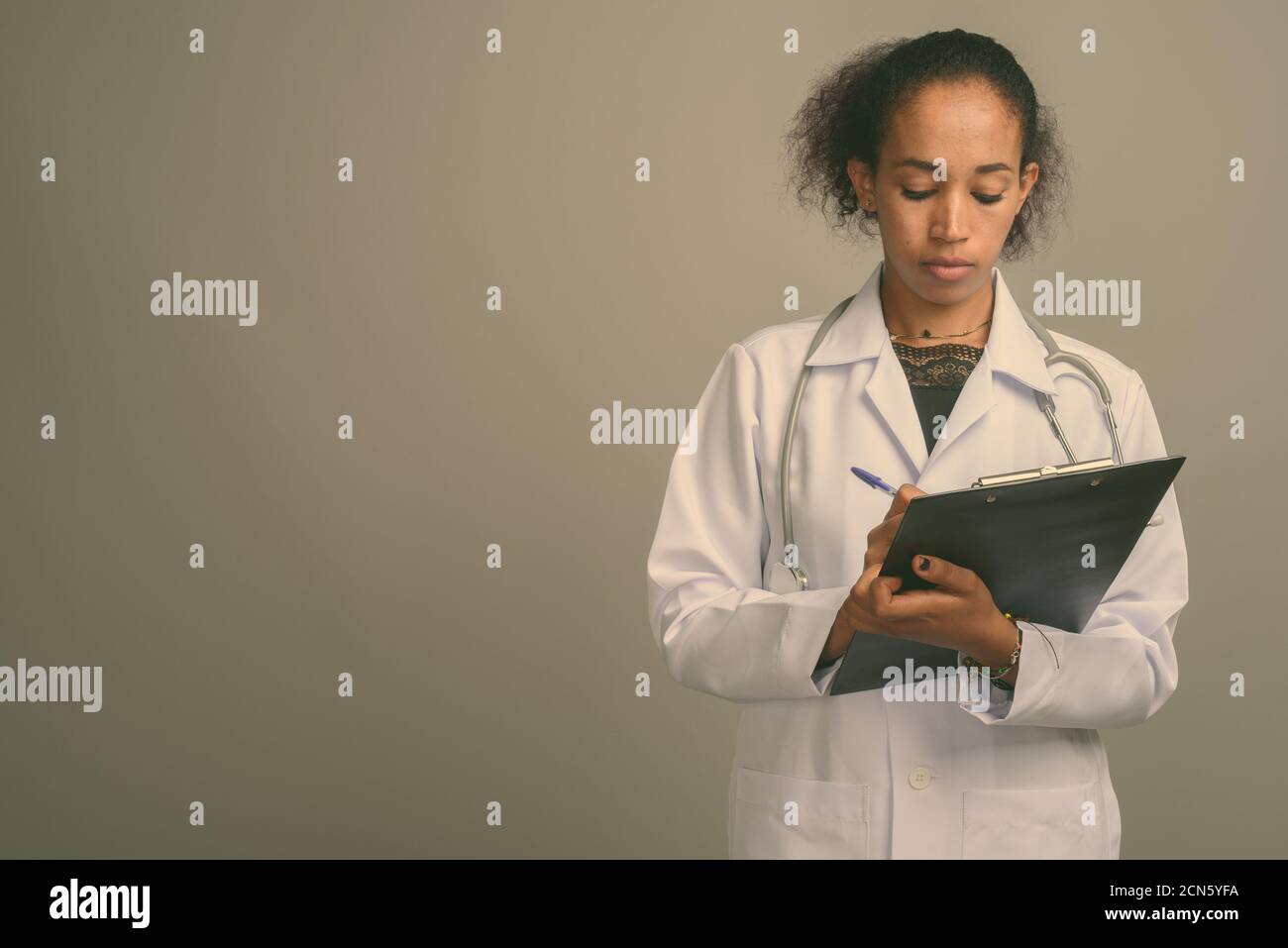 Young beautiful African woman doctor against gray background Stock ...