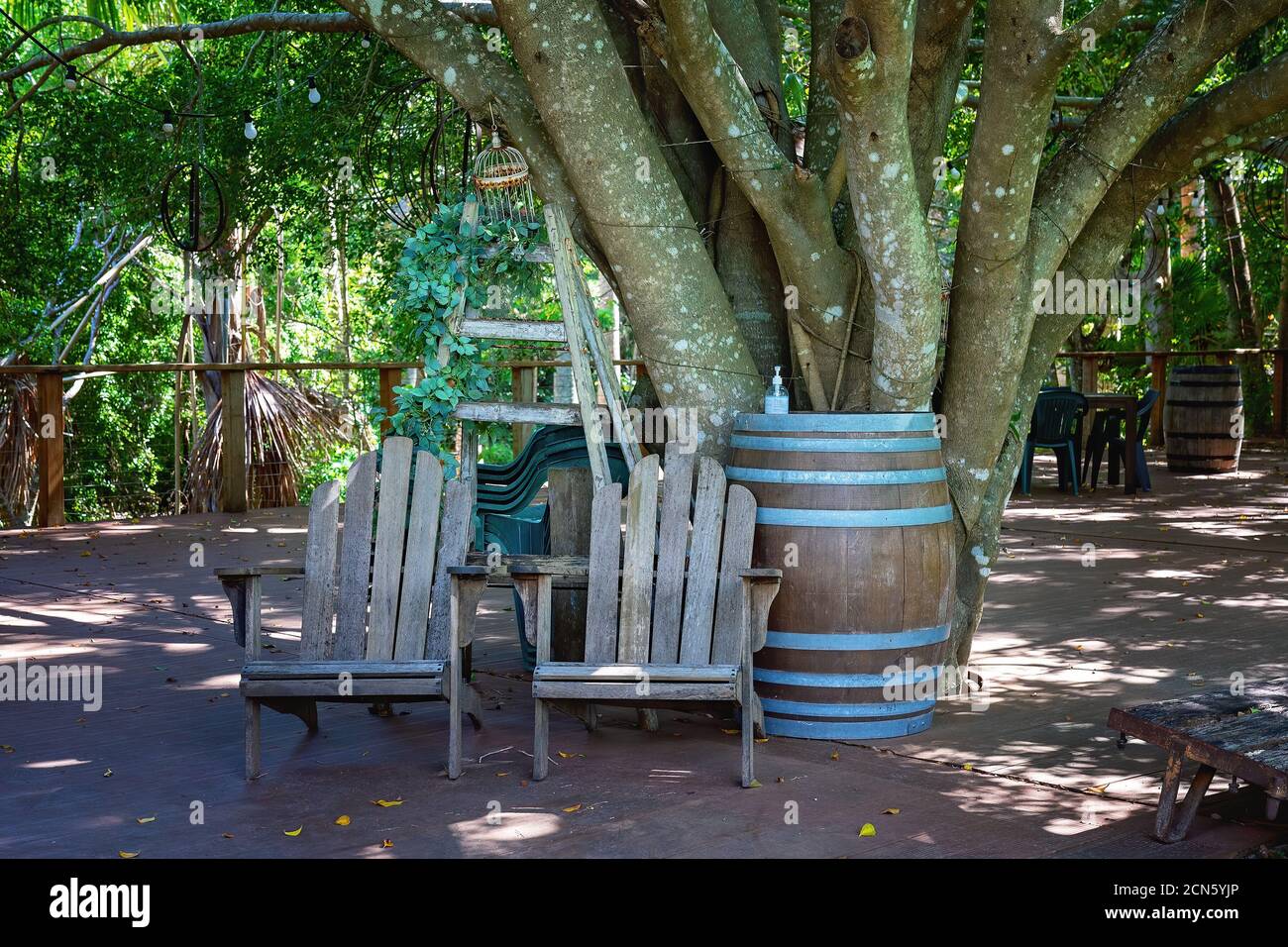 A casual outdoor seat setting with wine barrel table on a timber deck ...