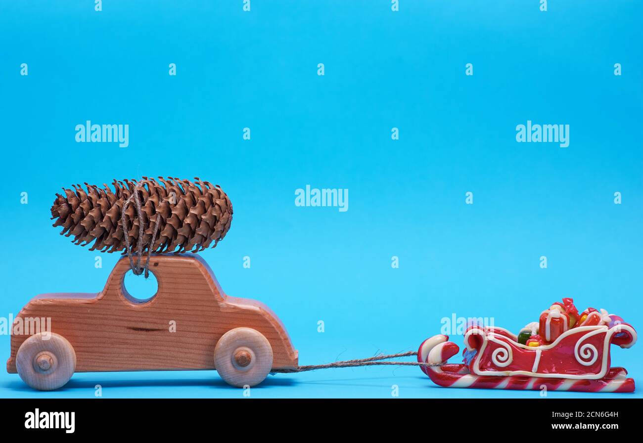 wooden toy car carries on top a pine cone on a blue background Stock ...