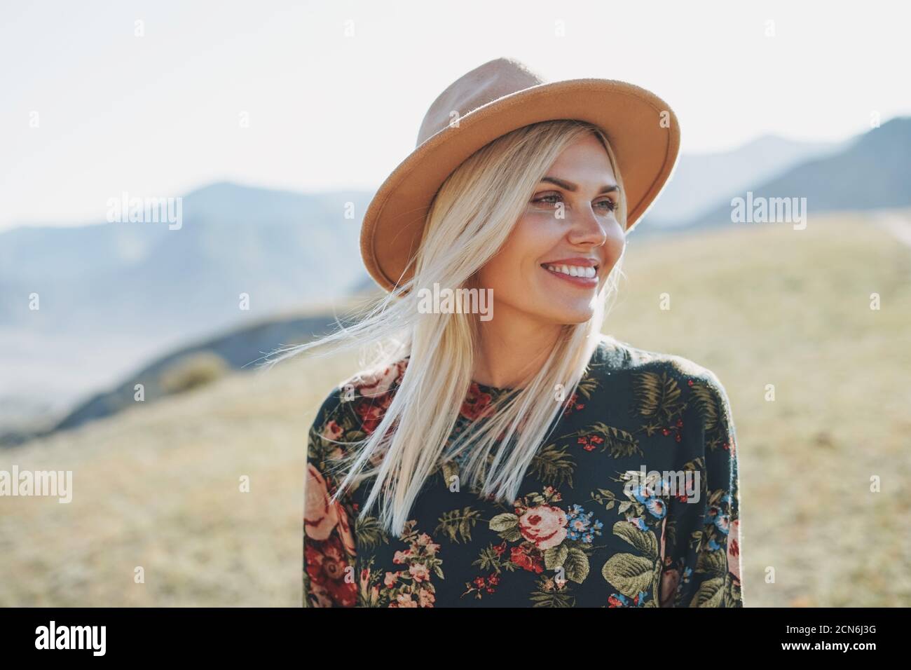 Beautiful smiling blone young woman traveler in dress and felt hat on ...