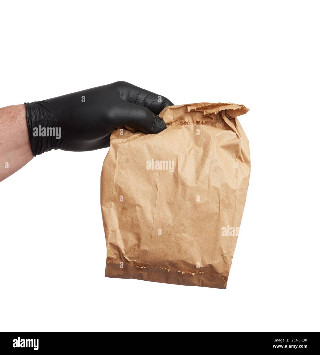 hand in a black latex glove holds a full paper bag of brown craft paper ...