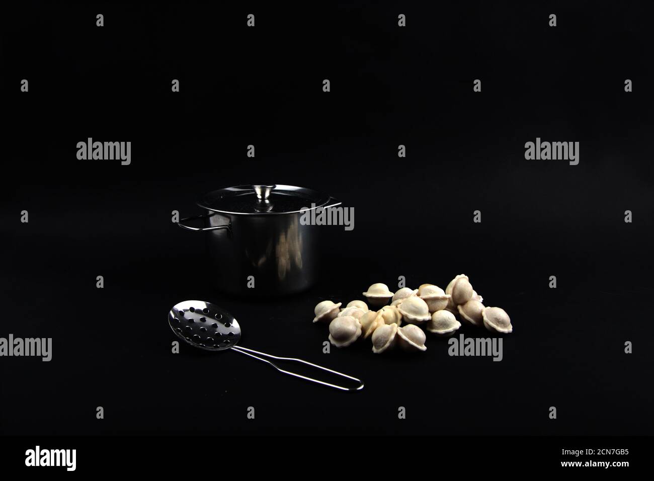 Uncooked russian pelmeni and flour on black background flat lay ...