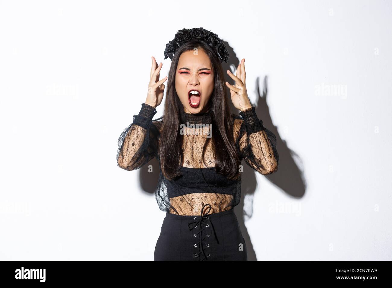 Image of angry asian woman in witch costume yelling at someone, looking ...