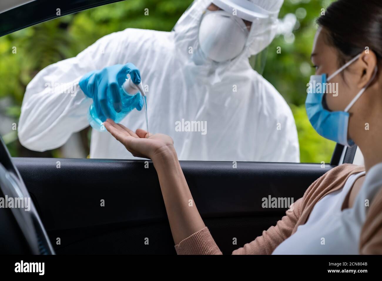 Medical staff give hand sanitiser at drive thru hospital Stock Photo ...