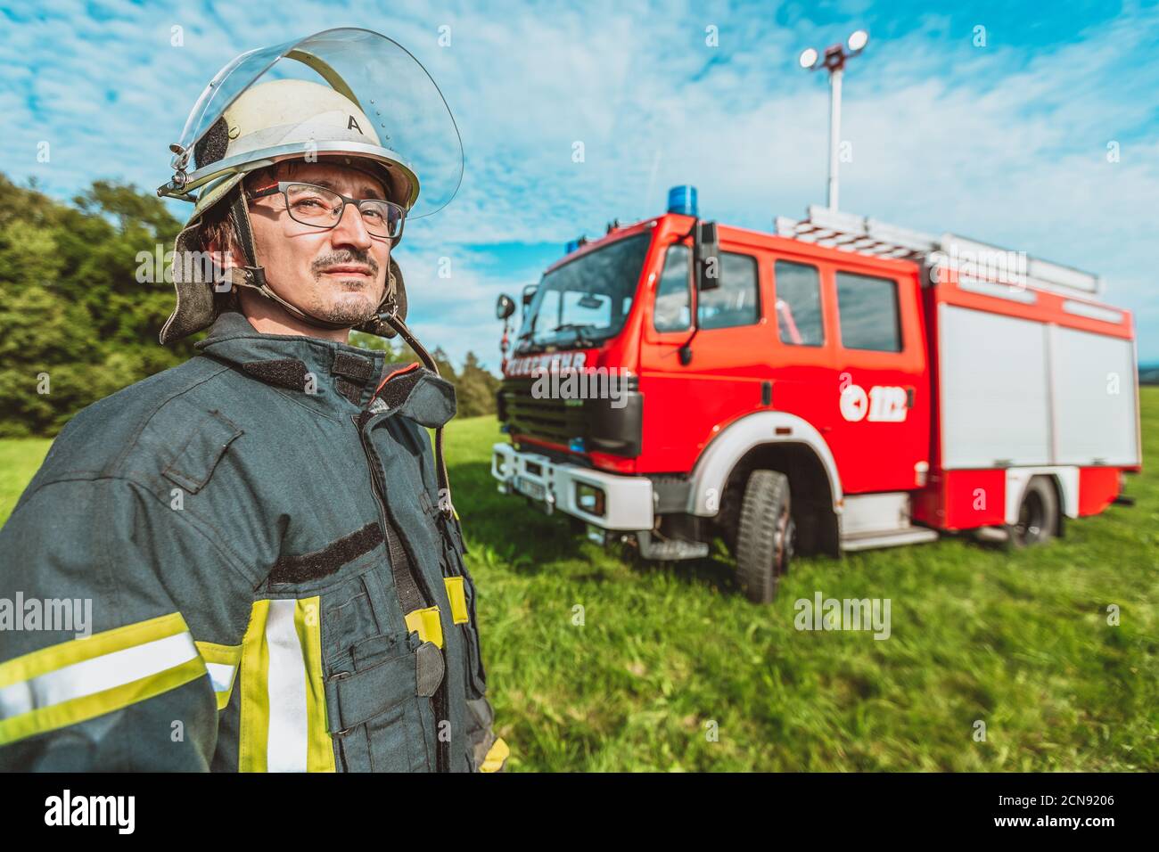 A german fireman stands near a firetruck Stock Photo - Alamy