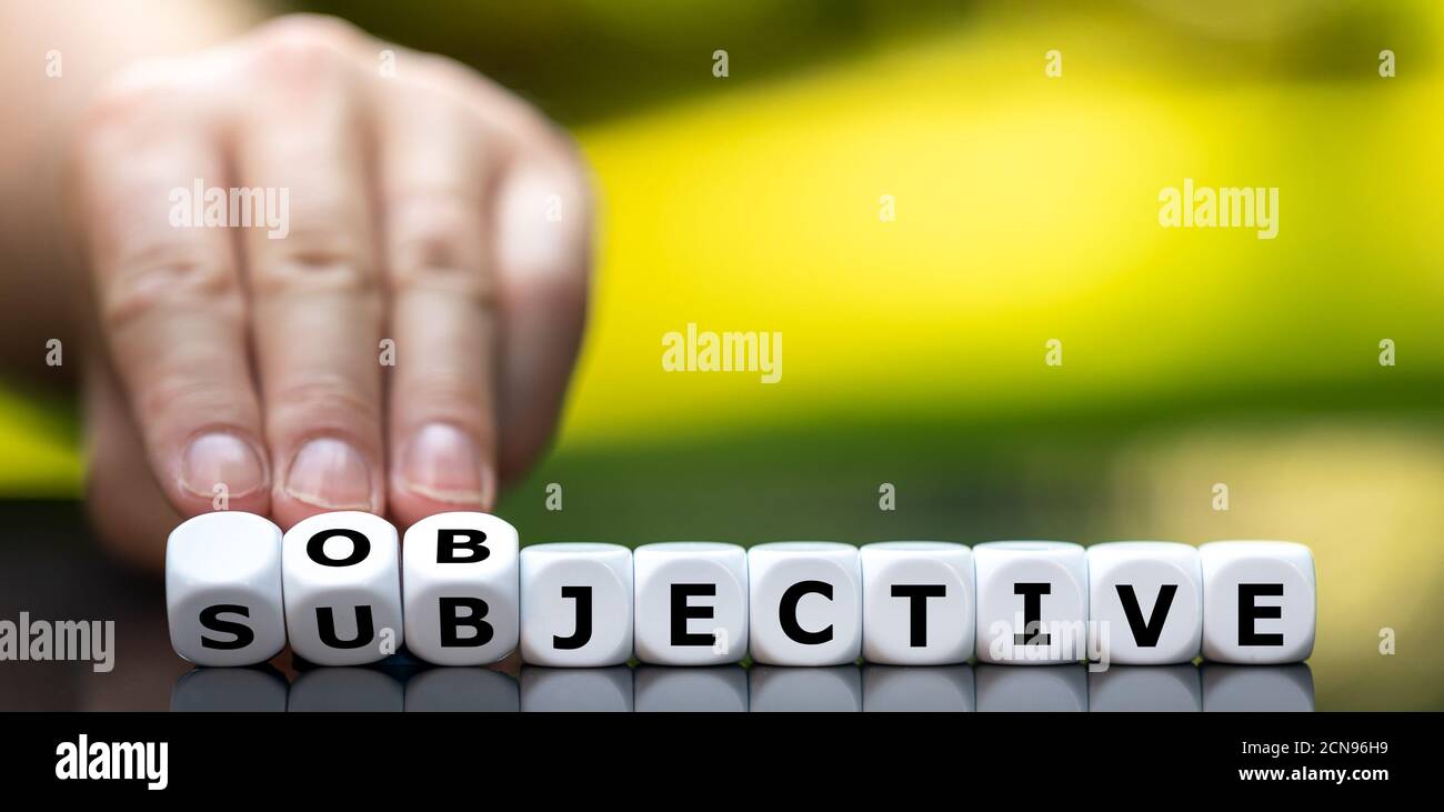 Hand turns dice and changes the word "subjective" to "objective Stock ...