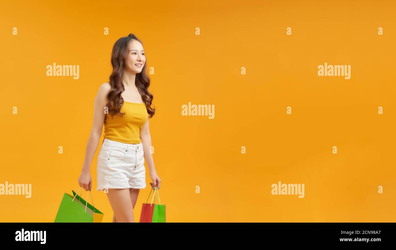 Surprised asian woman runs with paper bags Stock Photo - Alamy