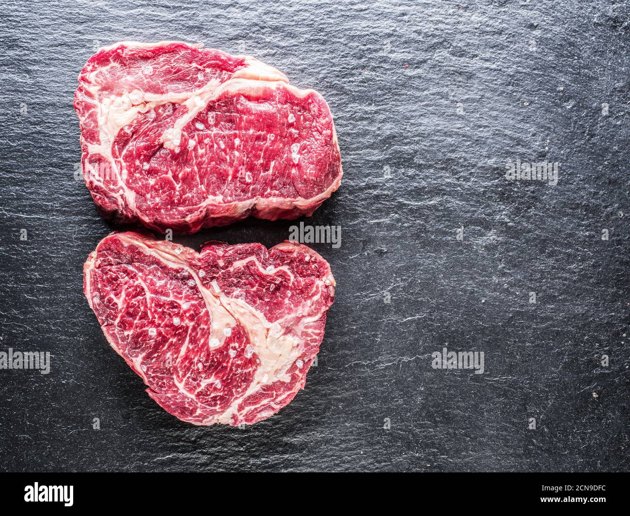 Rib eye steaks on the black background Stock Photo - Alamy