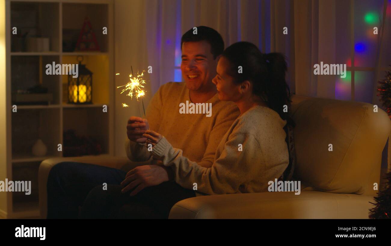 Romantic young couple holding hand fireworks celebrating christmas ...
