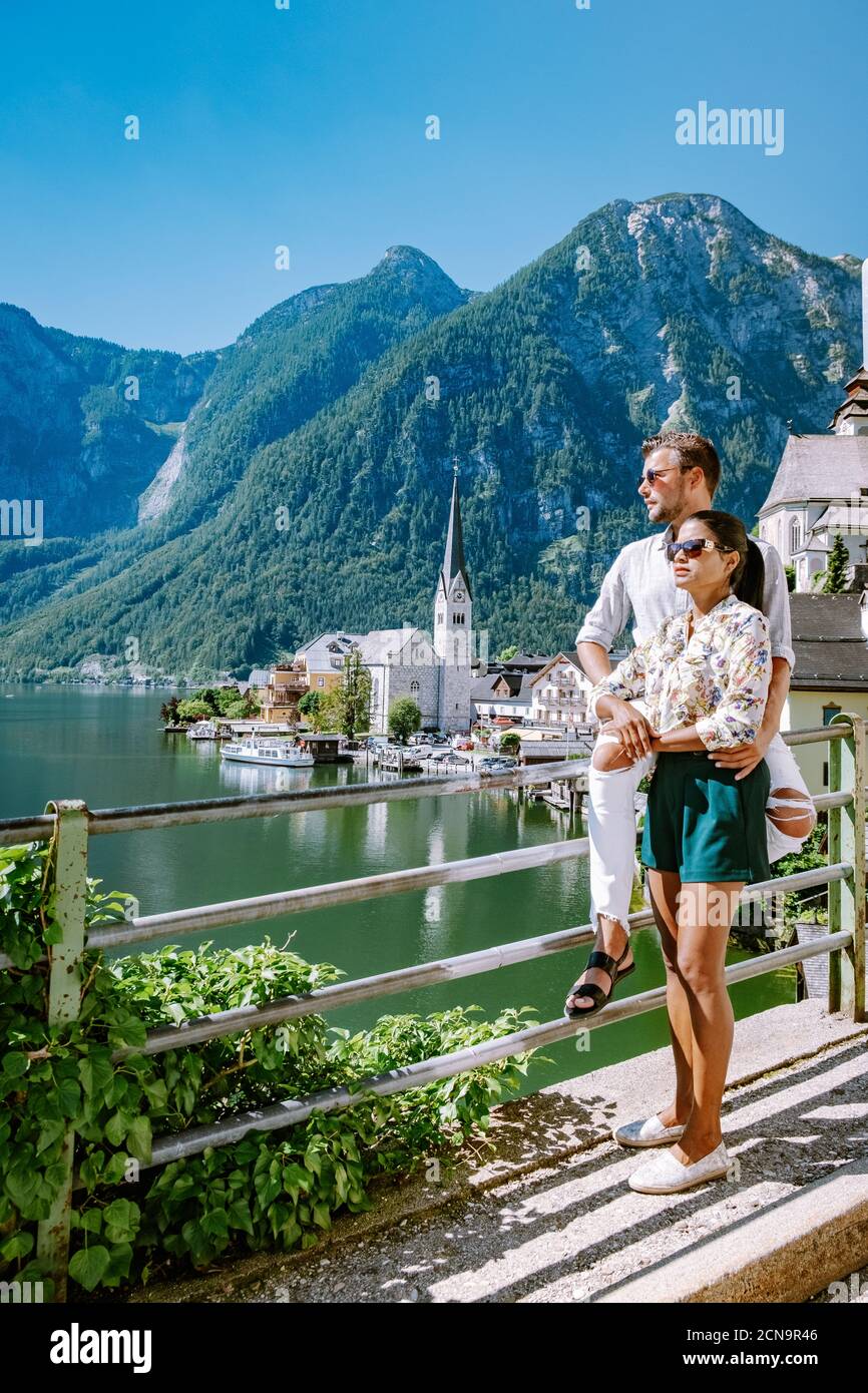 couple visit Hallstatt village on Hallstatter lake in Austrian Alps ...
