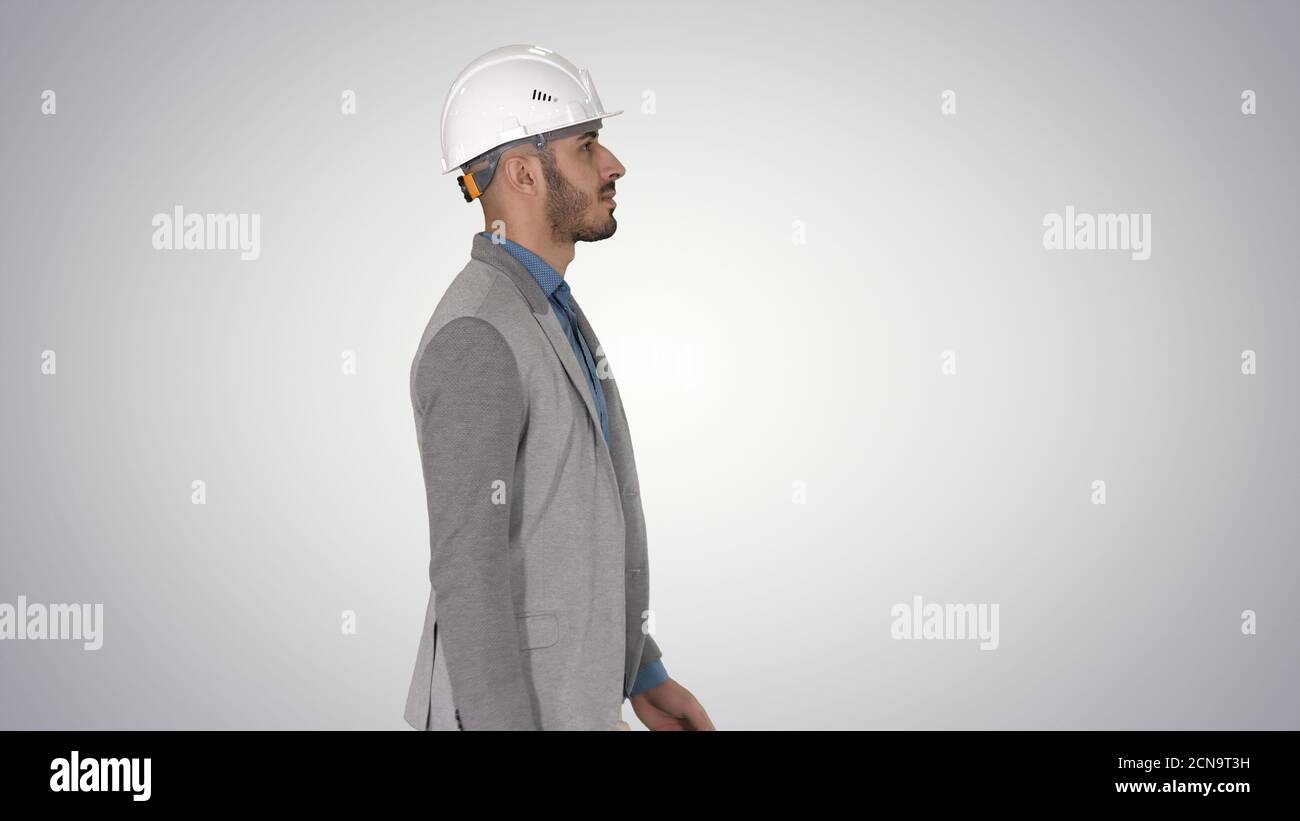 Architect in white helmet walking on gradient background Stock Photo ...
