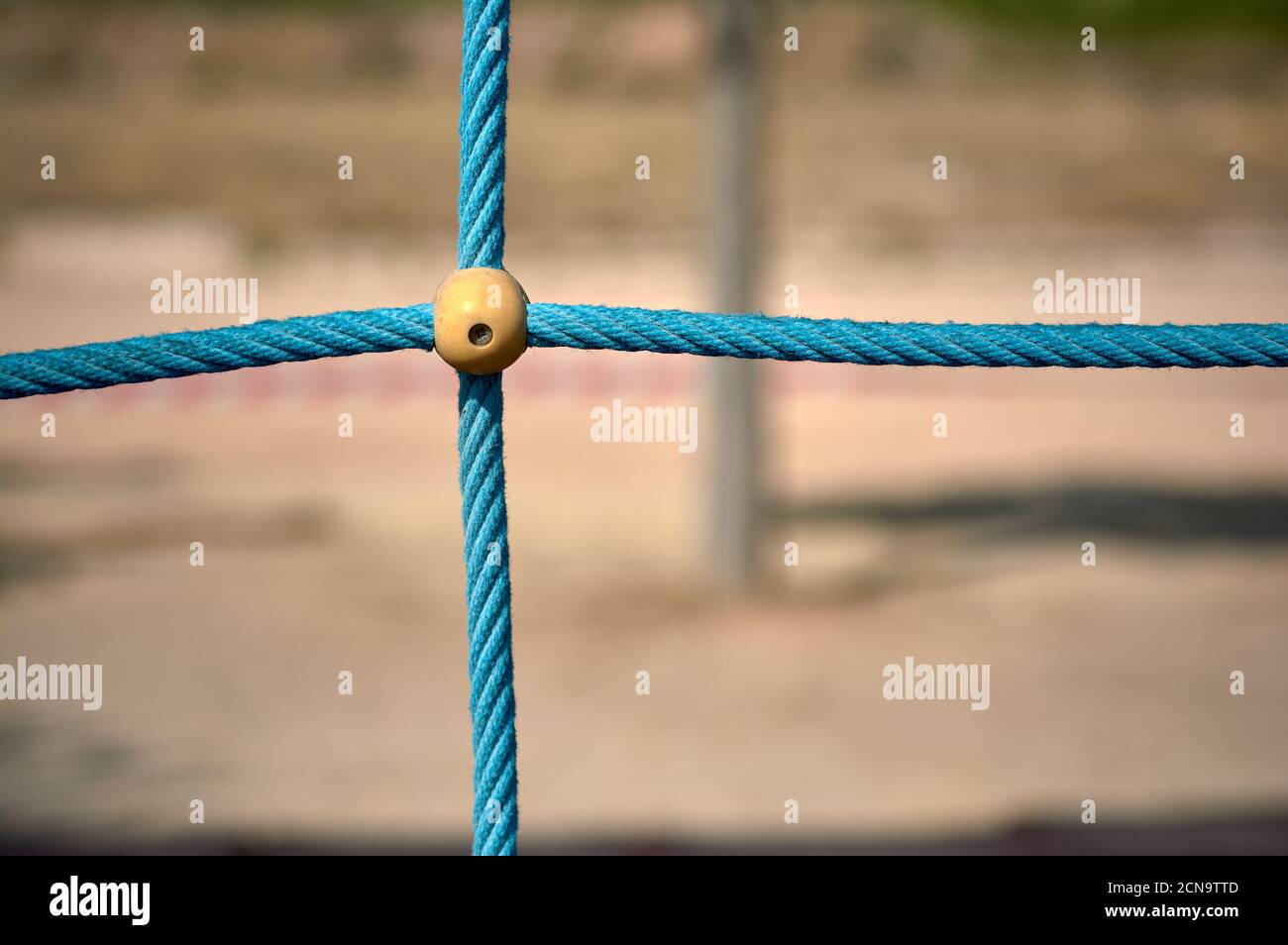 detail of a yellow connection of some blue ropes of an attraction of a ...