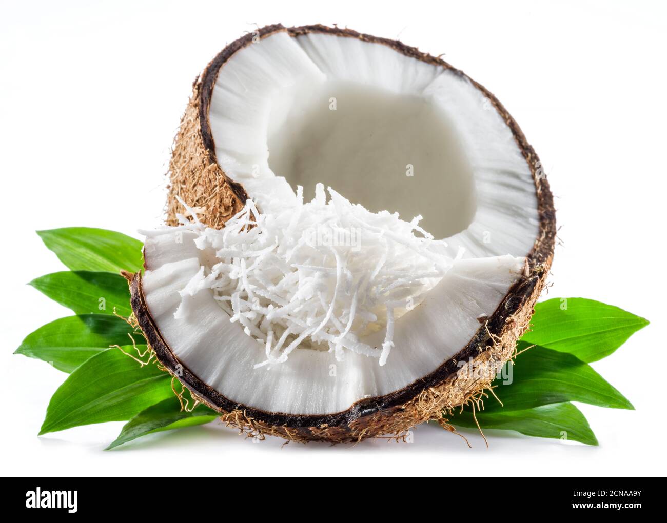 Cracked coconut fruit with white flesh and shredded coconut flakes ...