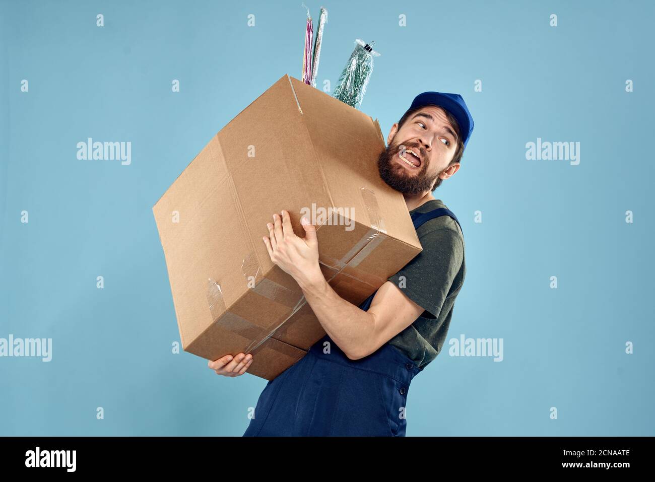 A man in working uniform with boxes in the hands of a carriage delivery ...