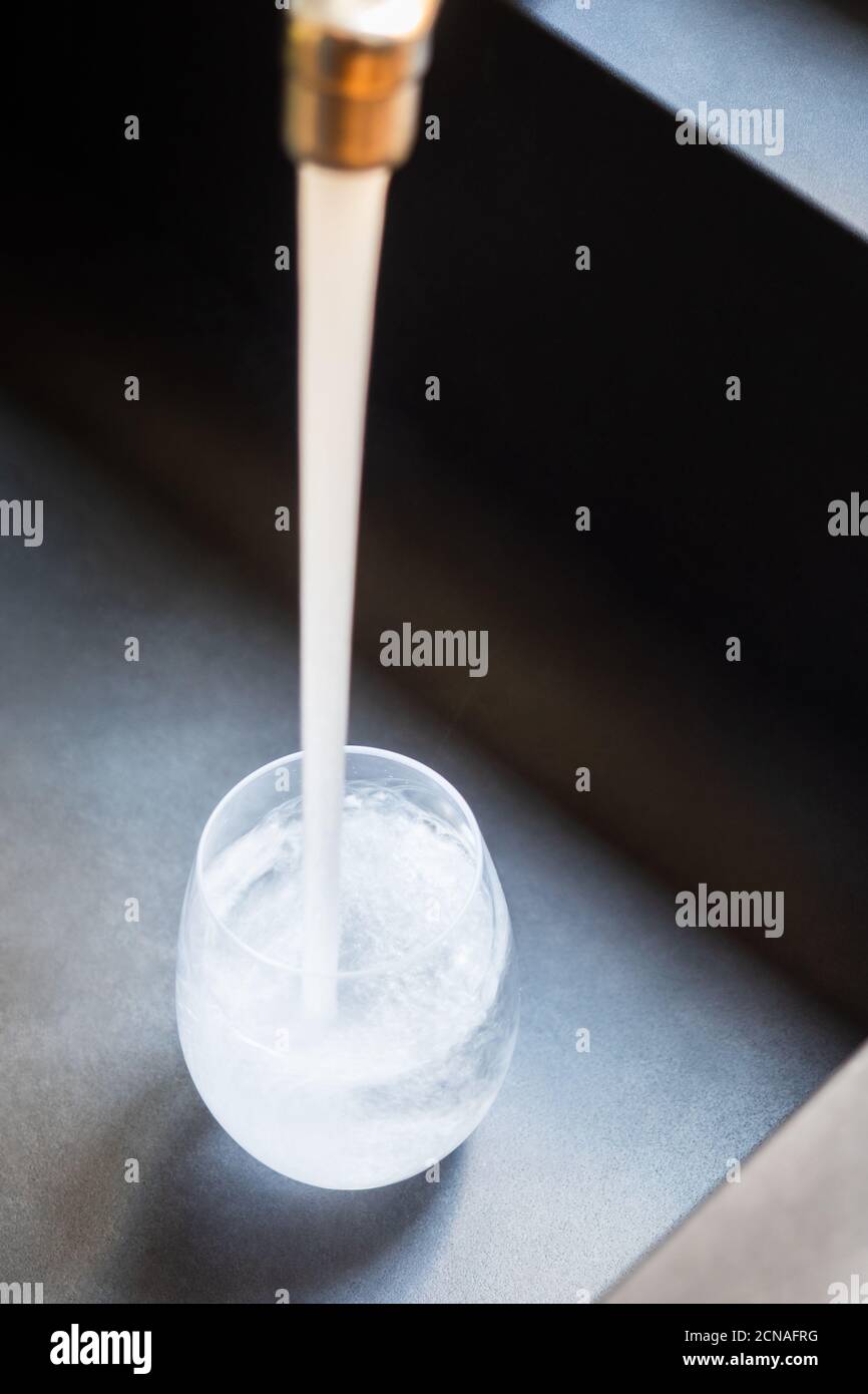 Glass of water filled at the tap with strong pressure Stock Photo - Alamy