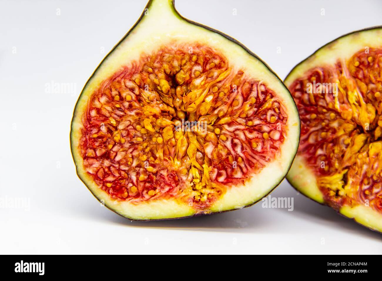 Two halves of figs isolated on a white background. View of ripe purple ...