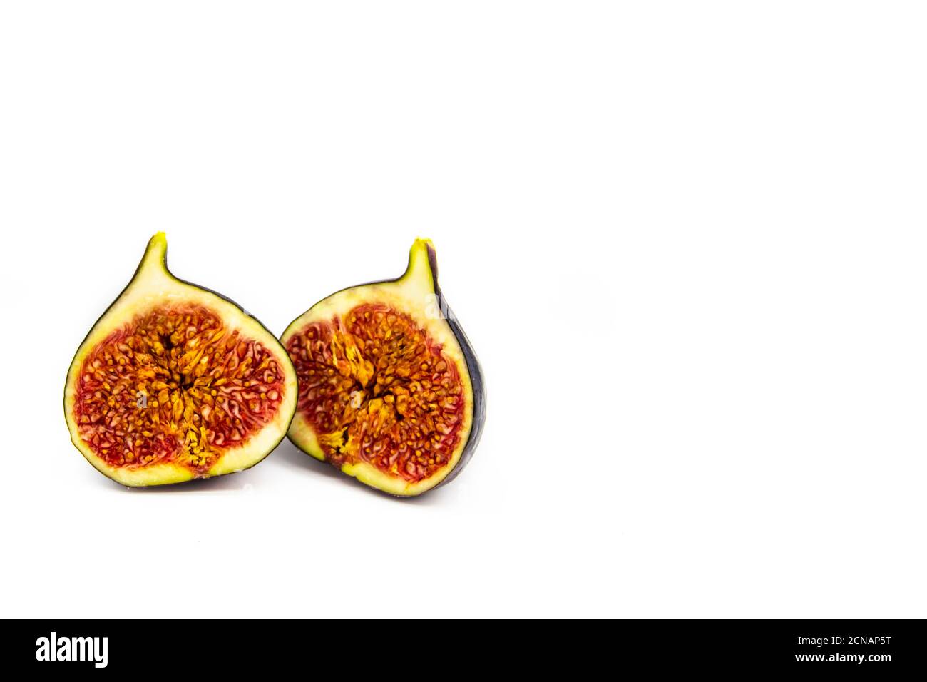 Two halves of figs isolated on a white background. View of ripe purple ...