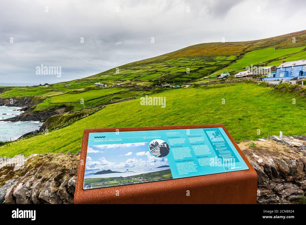 Information board on Slea Head Viewing Point with small cottage in the ...