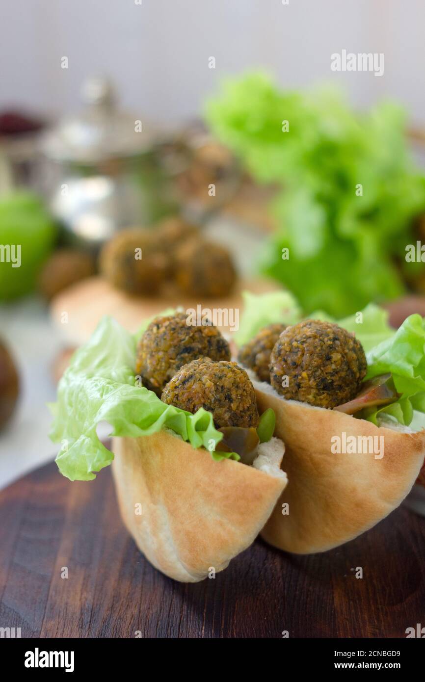Wooden board with falafel in pita inside Stock Photo - Alamy