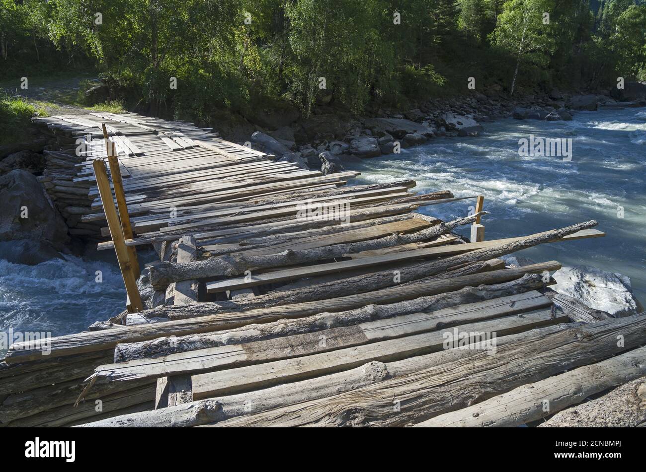 Old dilapidated bridge on the mountain river Stock Photo - Alamy