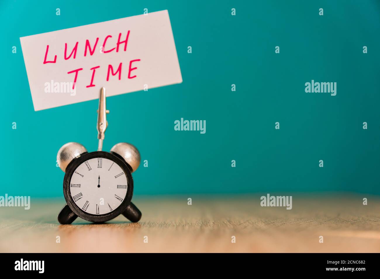 Alarm clock and banner with handwritten phrase"lunch time" on wooden ...