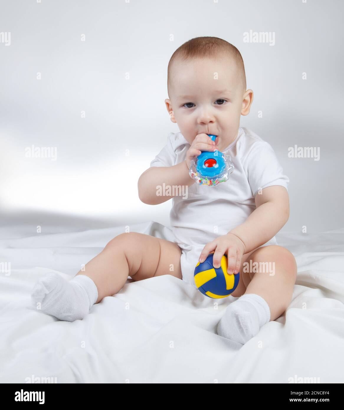 Photo of a ten-month-old baby with rattle and ball Stock Photo - Alamy