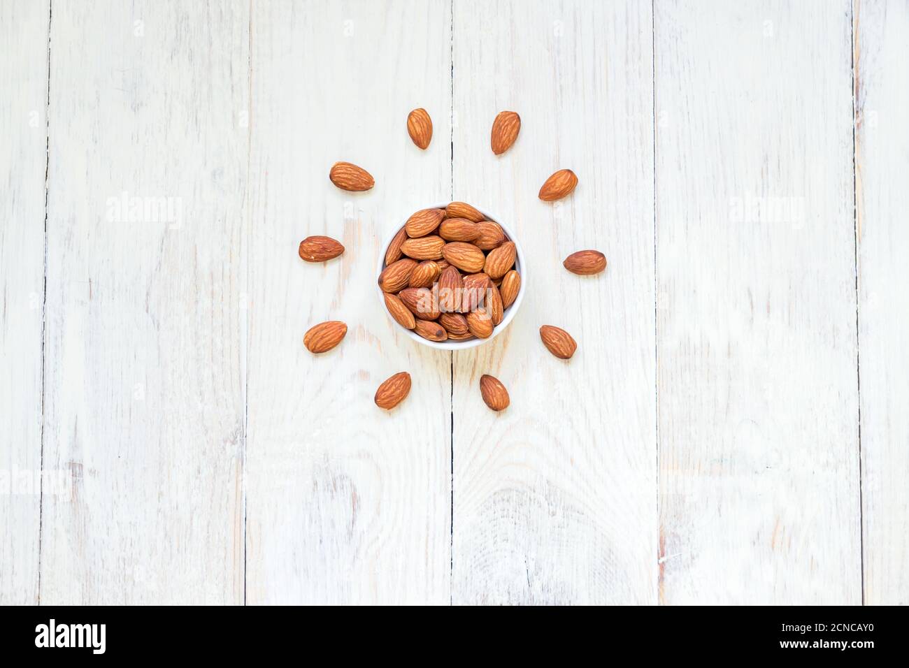 Top view of Roasted Almonds in white porcelain bowl on white wooden ...