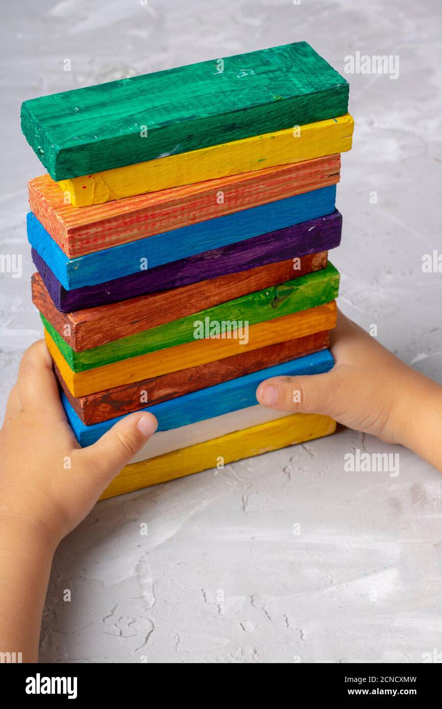 Kids hands holding wooden blocks, vertical photo Stock Photo - Alamy