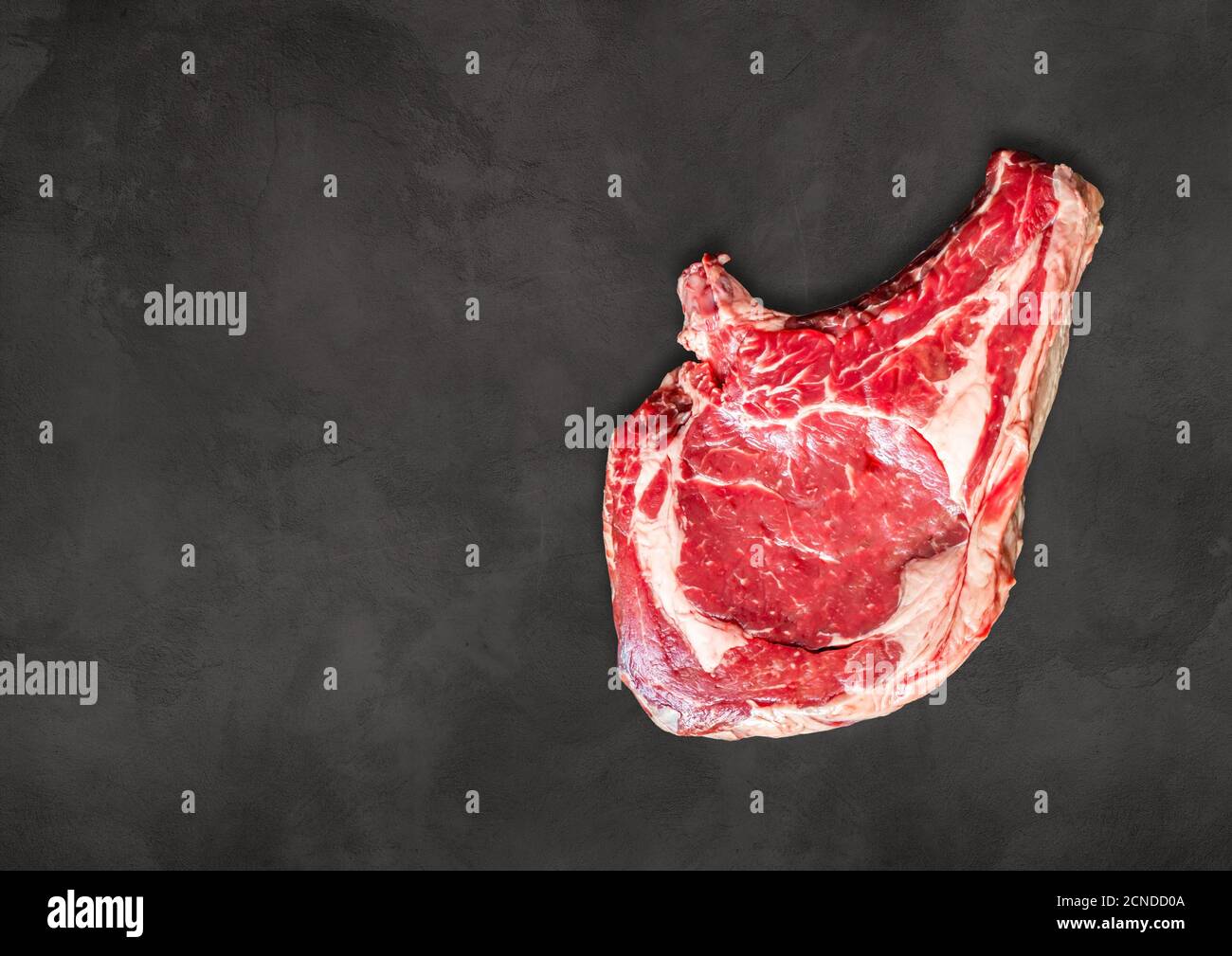 Raw beef prime rib on a concrete background. Top view Stock Photo - Alamy