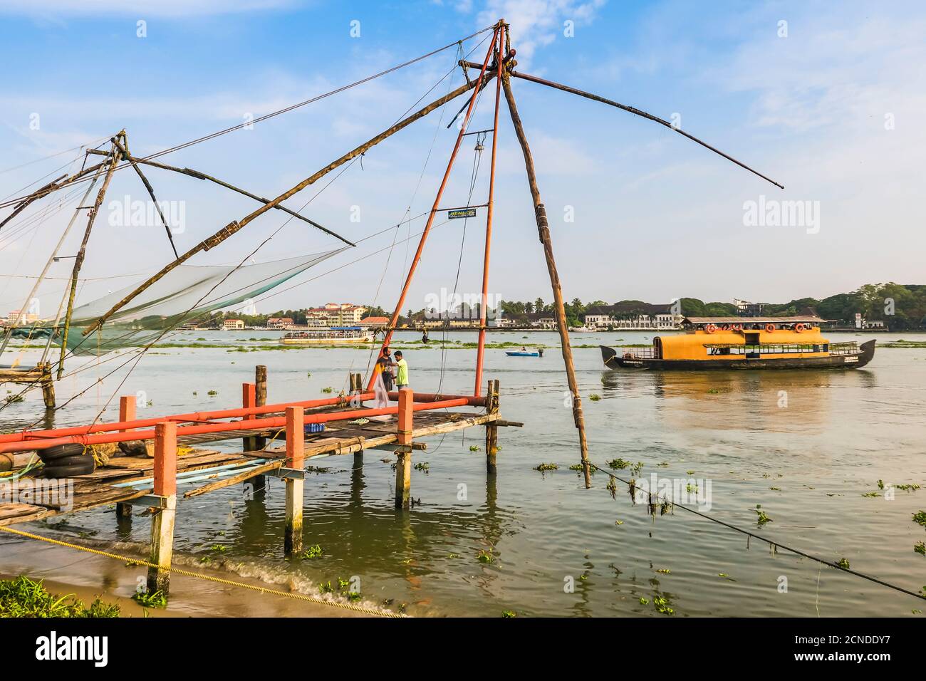 Old Chinese fishing nets and tour boat on the waterfront of Vypin ...