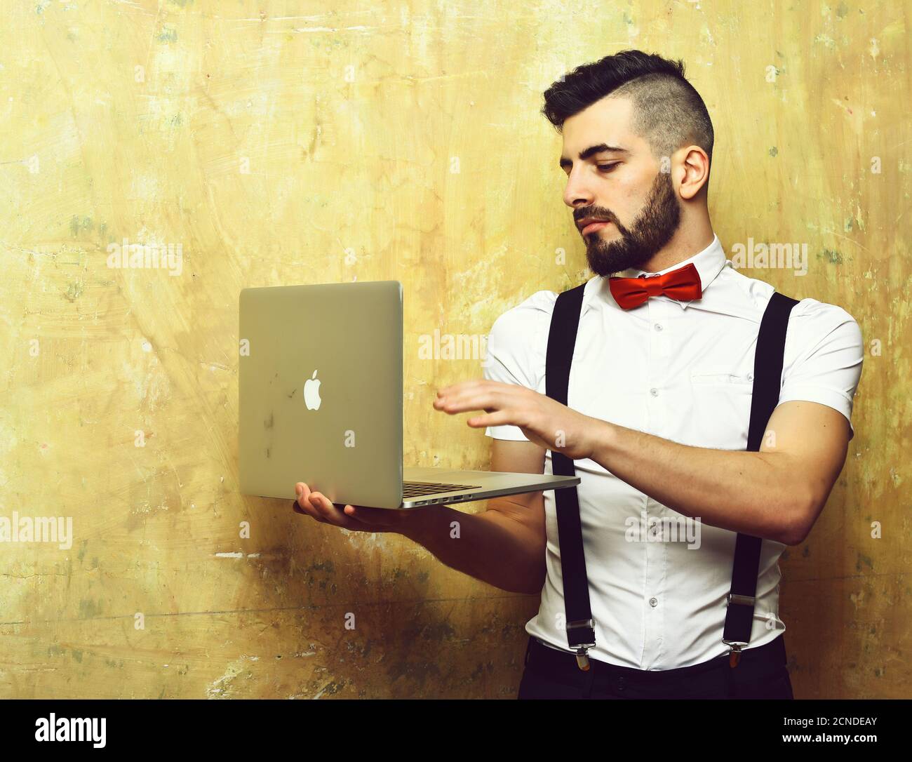 Man with beard with beard in modern stylish outfit uses laptop on ...