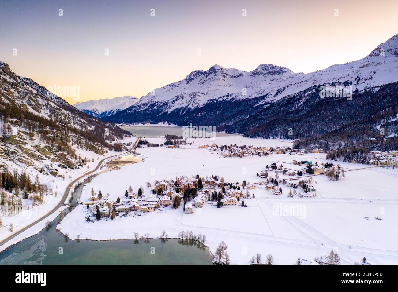 Snowy village of Segl (Sils im Engadin) on shores of Lake Sils at dawn ...