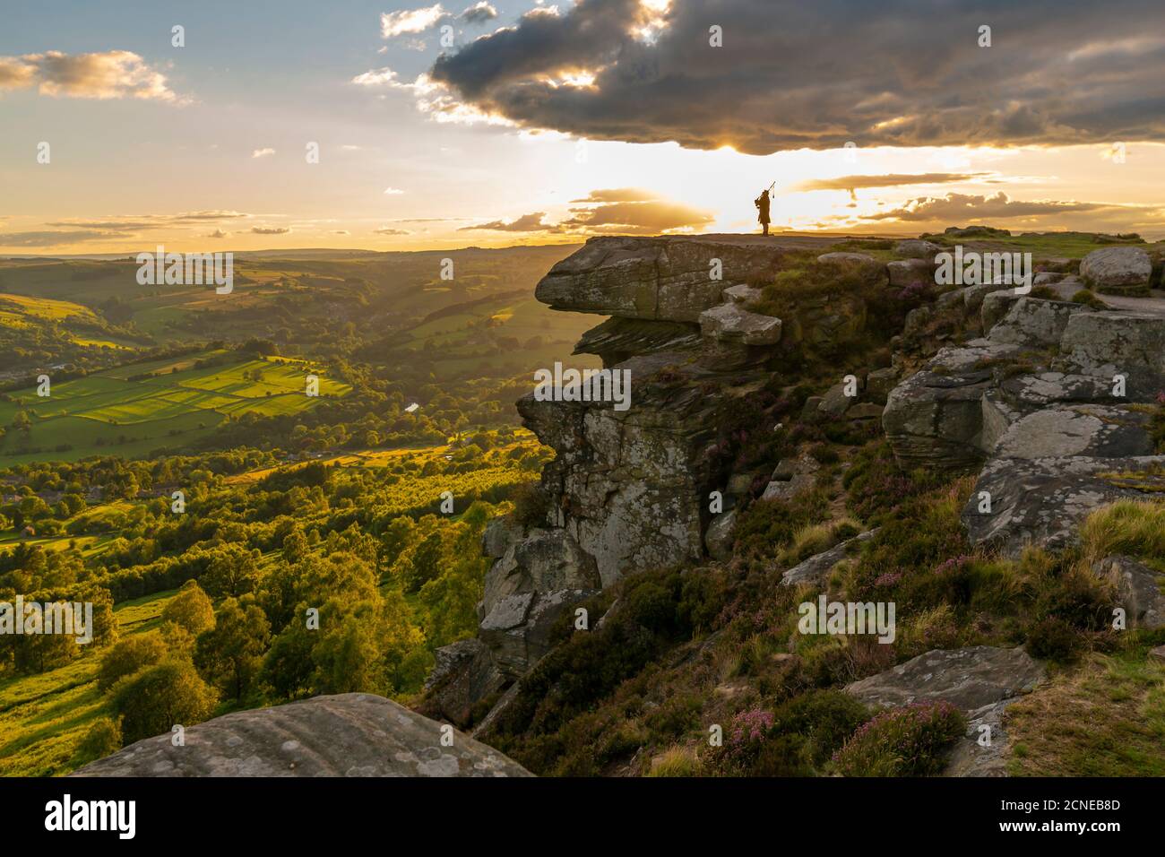 View of lone piper at at sunset on Curbar Edge, Curbar, Hope Valley ...