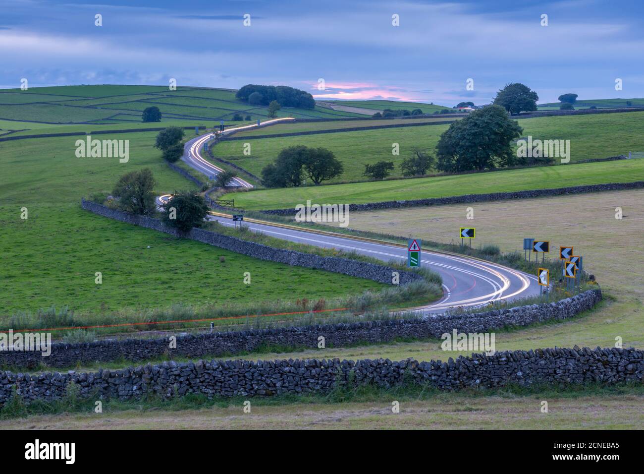 View of trail lights on winding road near Tideswell, Peak District ...