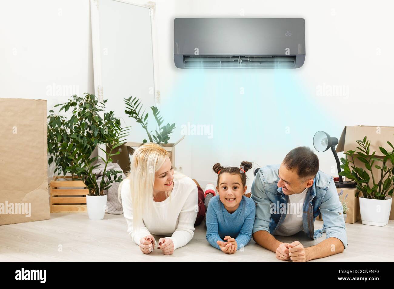 Happy Family Under Air Conditioning At Home Stock Photo - Alamy