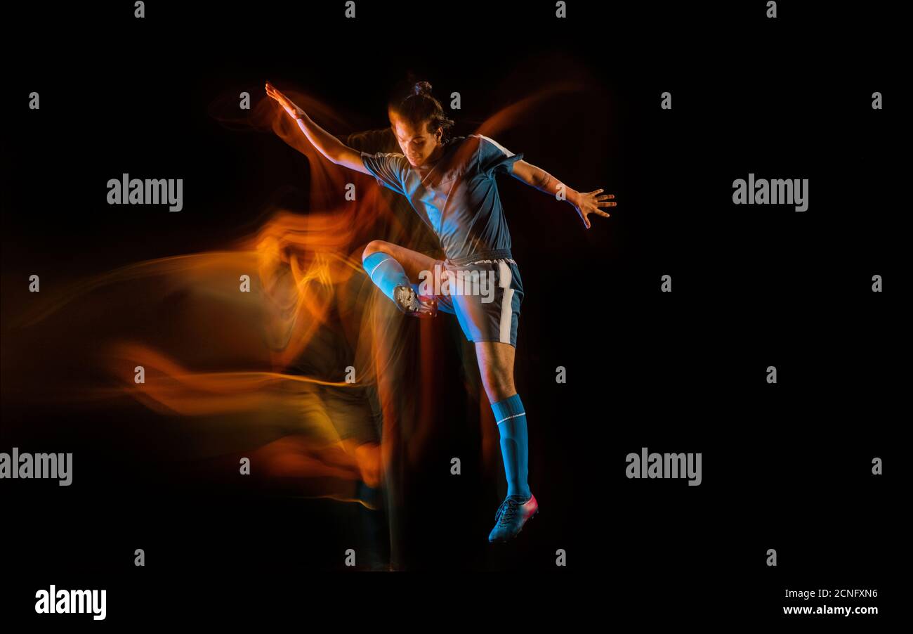 Jump high. Football or soccer player on black studio background in ...