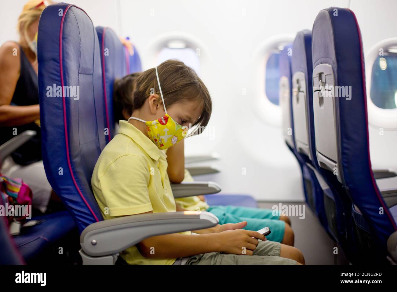 Toddler boy, child boarding on the airplane, sitting and waiting for ...